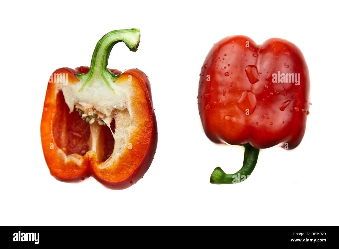 Red bell pepper halves with water droplets against a white background ...