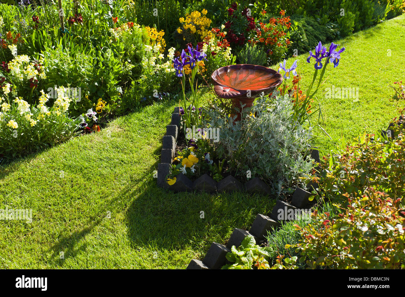 Tidy town garden, birdbath, flowers, borders Stock Photo - Alamy