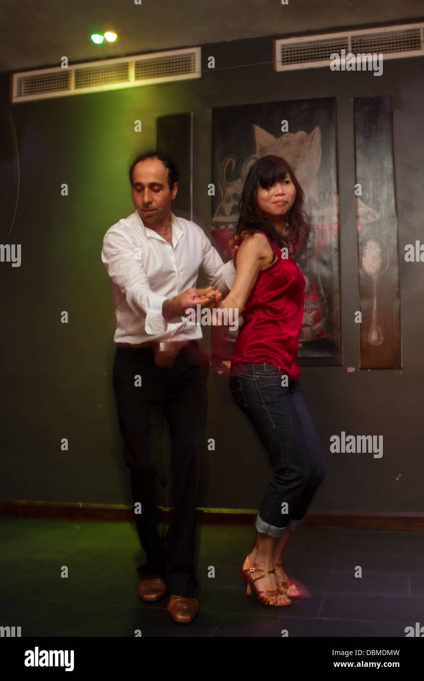 Young couple dancing salsa in a colourful bar Stock Photo - Alamy