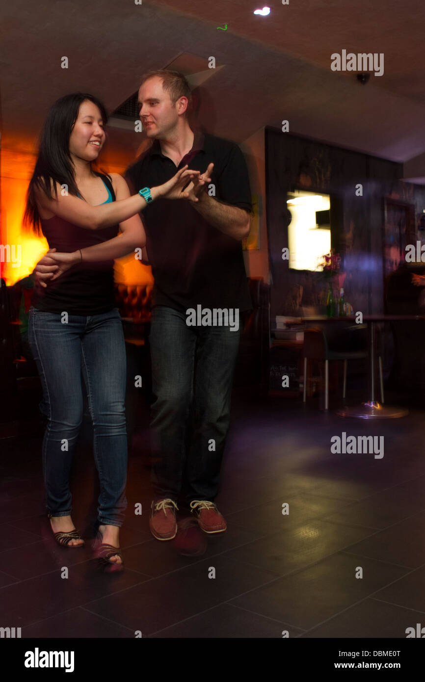 Young couple dancing salsa in a colourful bar Stock Photo - Alamy