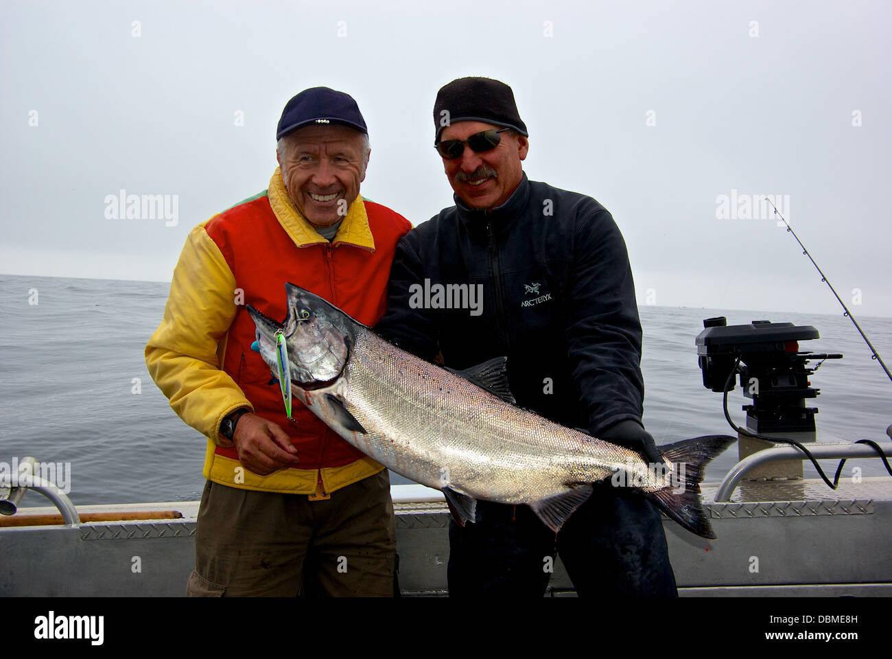 Happy smiling angler fishing guide holding big sport caught chinook ...