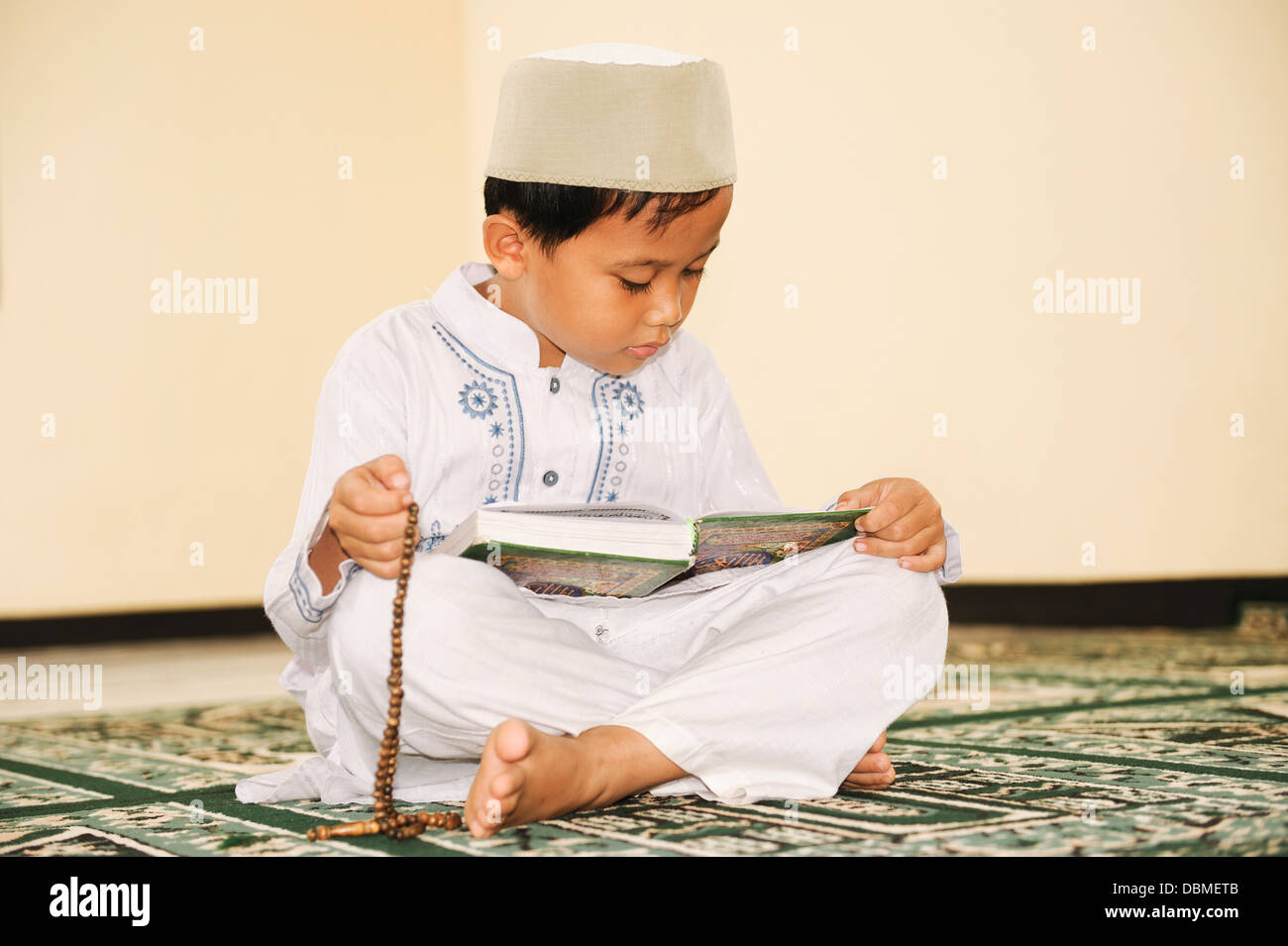 Muslim boy reading Koran In a Mosque Stock Photo - Alamy