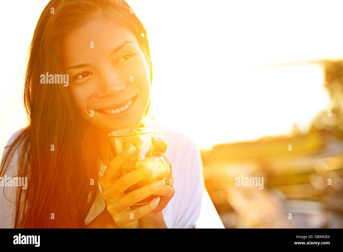 Woman drinking coffee in sunshine sitting outdoor in sun light enjoying ...