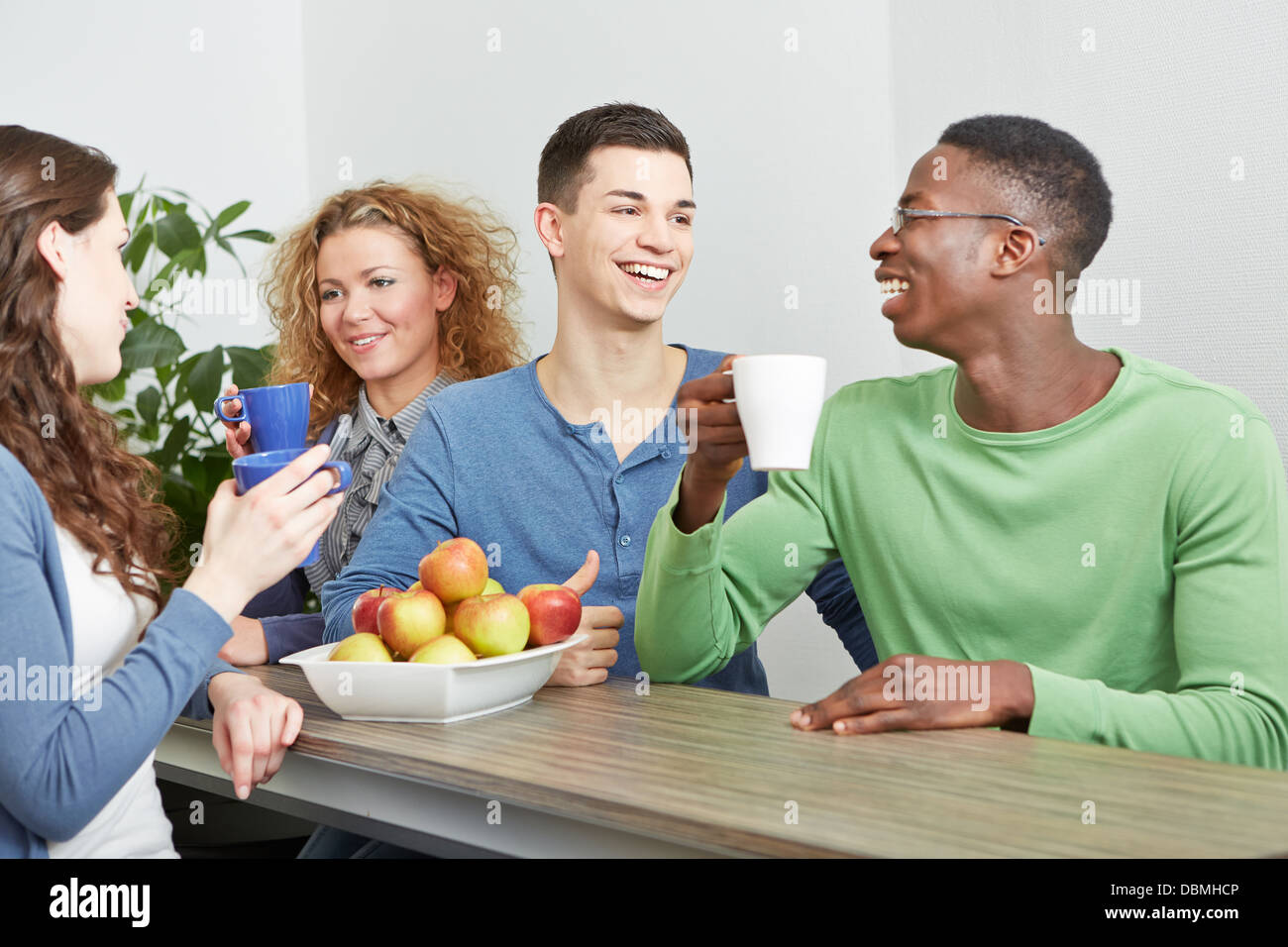 Many smiling colleagues drinking coffee in break room Stock Photo - Alamy