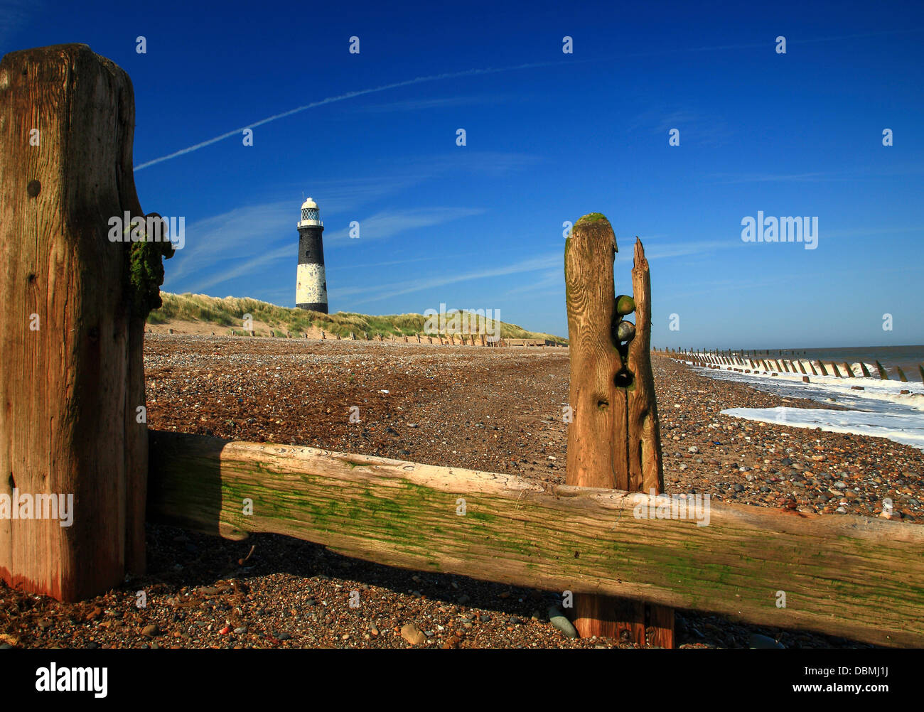 View of Spurn Point Lighthouse from the east side framed by sea defence ...