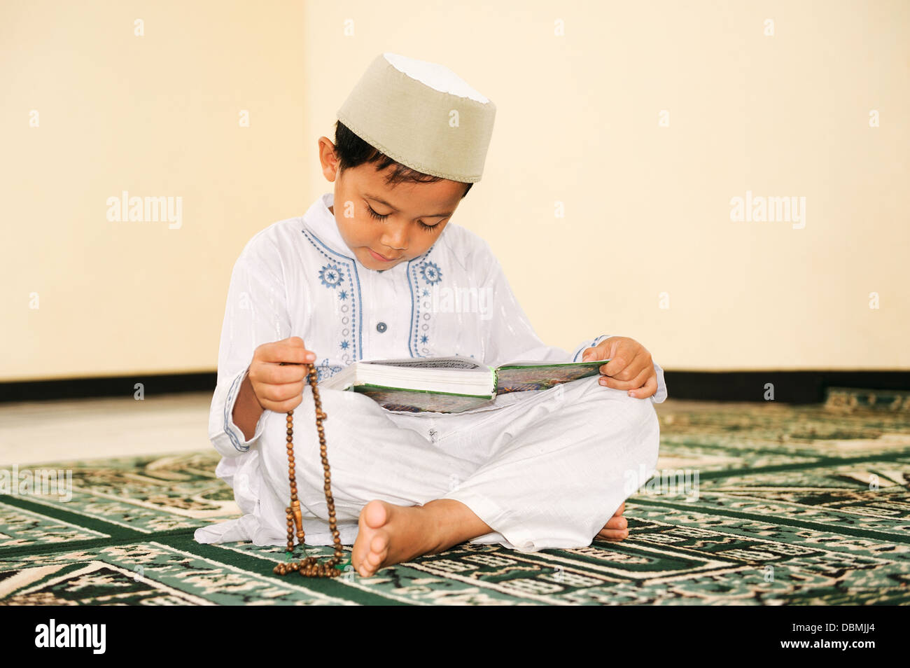 Muslim boy reading Koran In a Mosque Stock Photo - Alamy