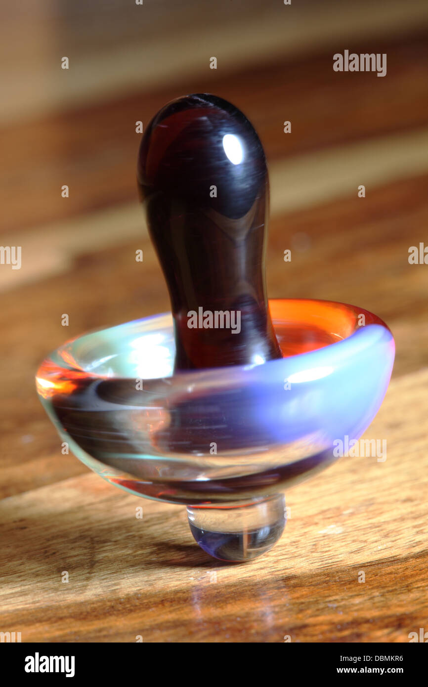 glass spinning top on wooden table Stock Photo - Alamy
