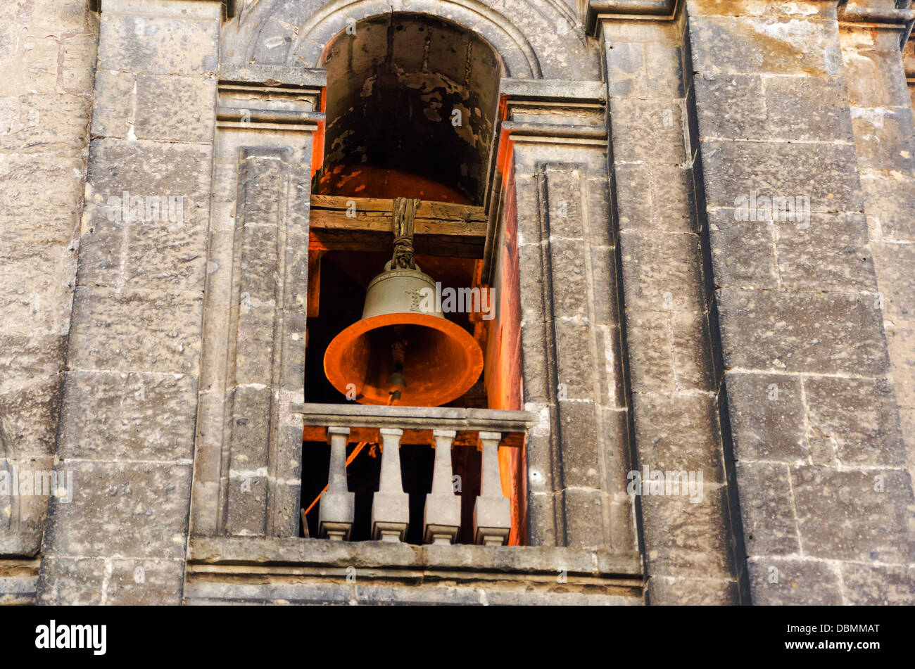 Orange light falling on a bell in the bell tower of the cathedral of ...