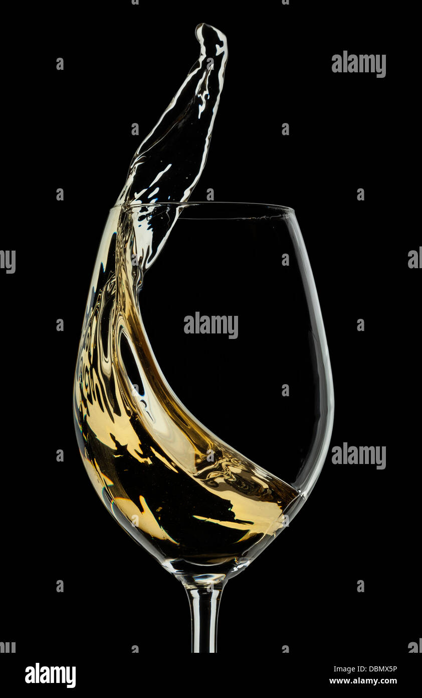 White wine splash on black background Stock Photo - Alamy