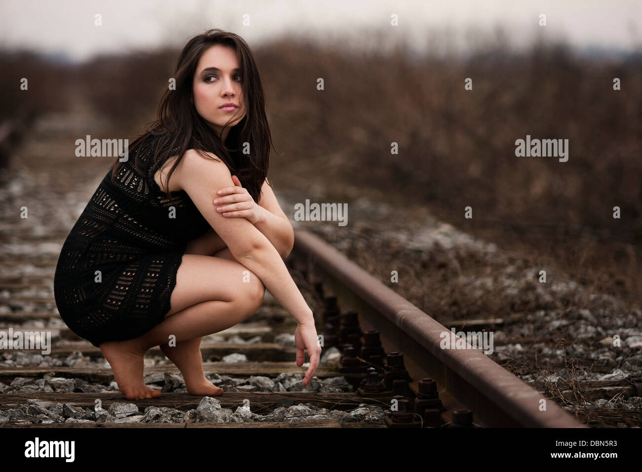 Young woman with long hair crouching on a railway track, Croatia Stock ... Young woman with long hair crouching on a railway track, Croatia Stock ...
