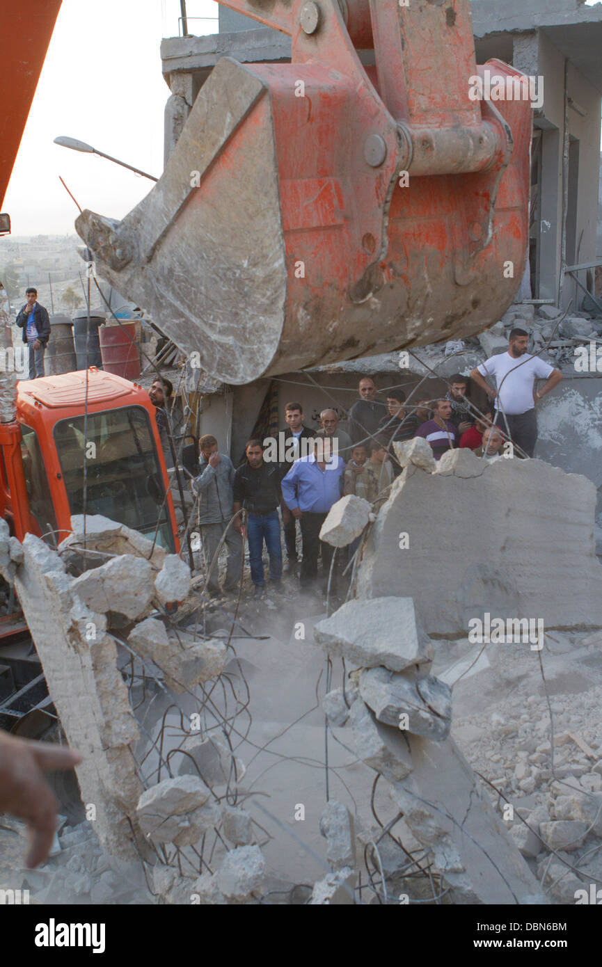 Aleppo, Syria: A back hoe clears rubble after a MIG bombing of ...