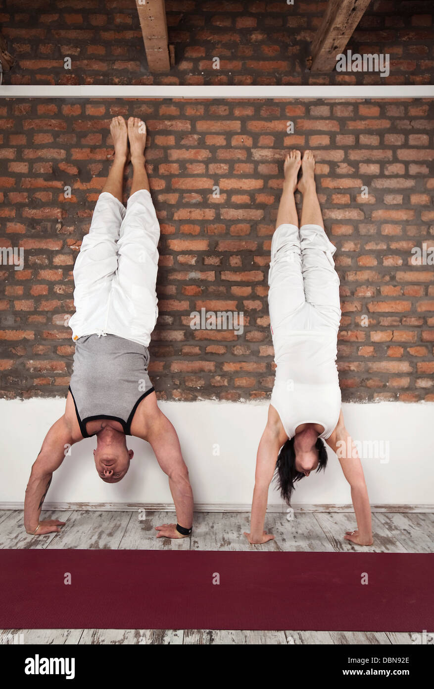 Couple Doing Handstand, Leaning On Wall Stock Photo - Alamy