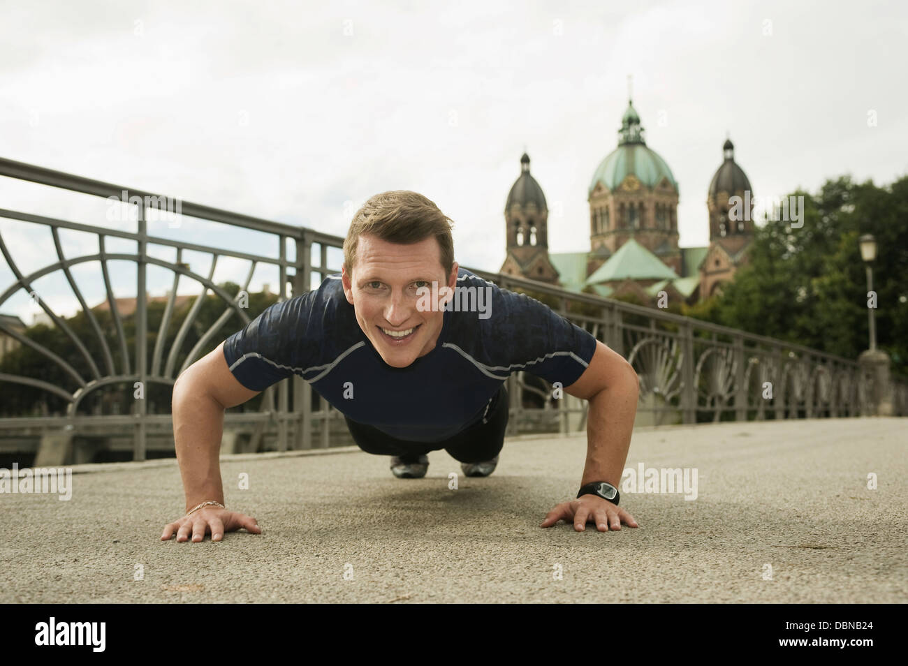 Young man doing push-ups on bridge, Munich, Bavaria, Germany Stock ...