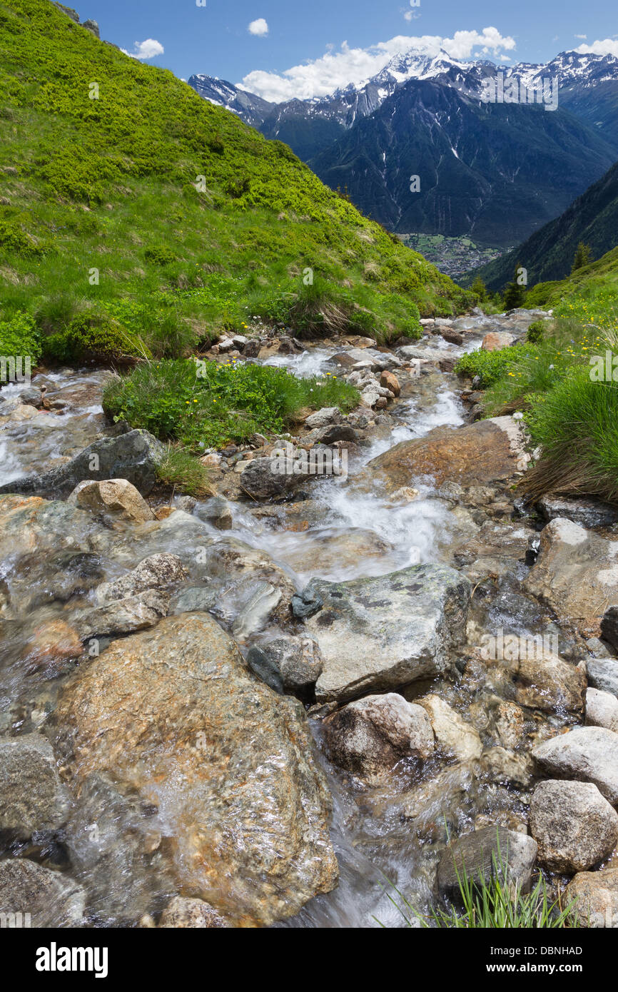 Alpine stream running over rocks and down into a picturesque Swiss ...