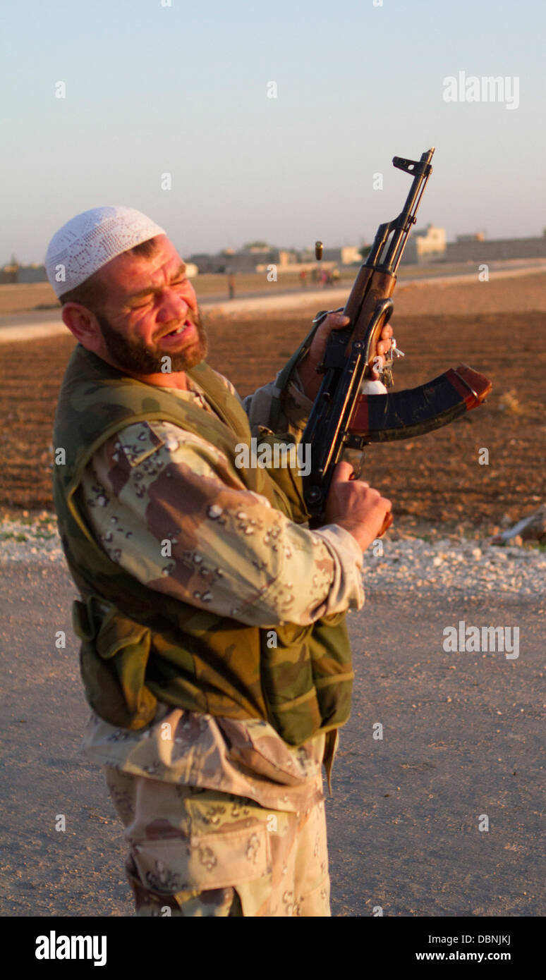 A Free Syrian Army rebel fires his AK-47 into the air in Aleppo, Syria ...