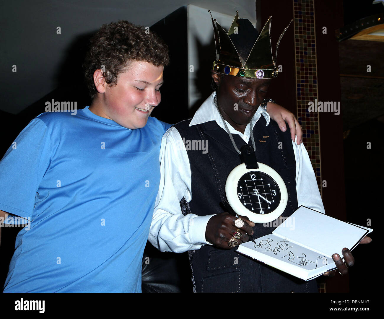 Flavor Flav and a fan Flavor Flav signs copies of his new book 'Flavor ...