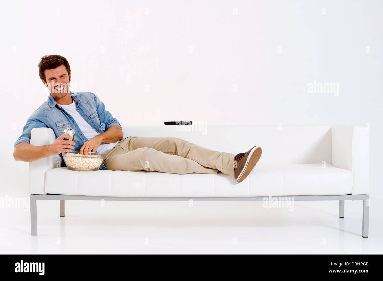 single man on the couch watching TV Stock Photo - Alamy