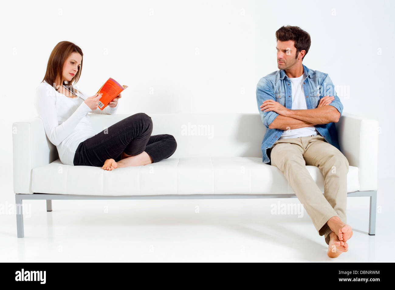 separated couple on the sofa woman reading a book Stock Photo - Alamy
