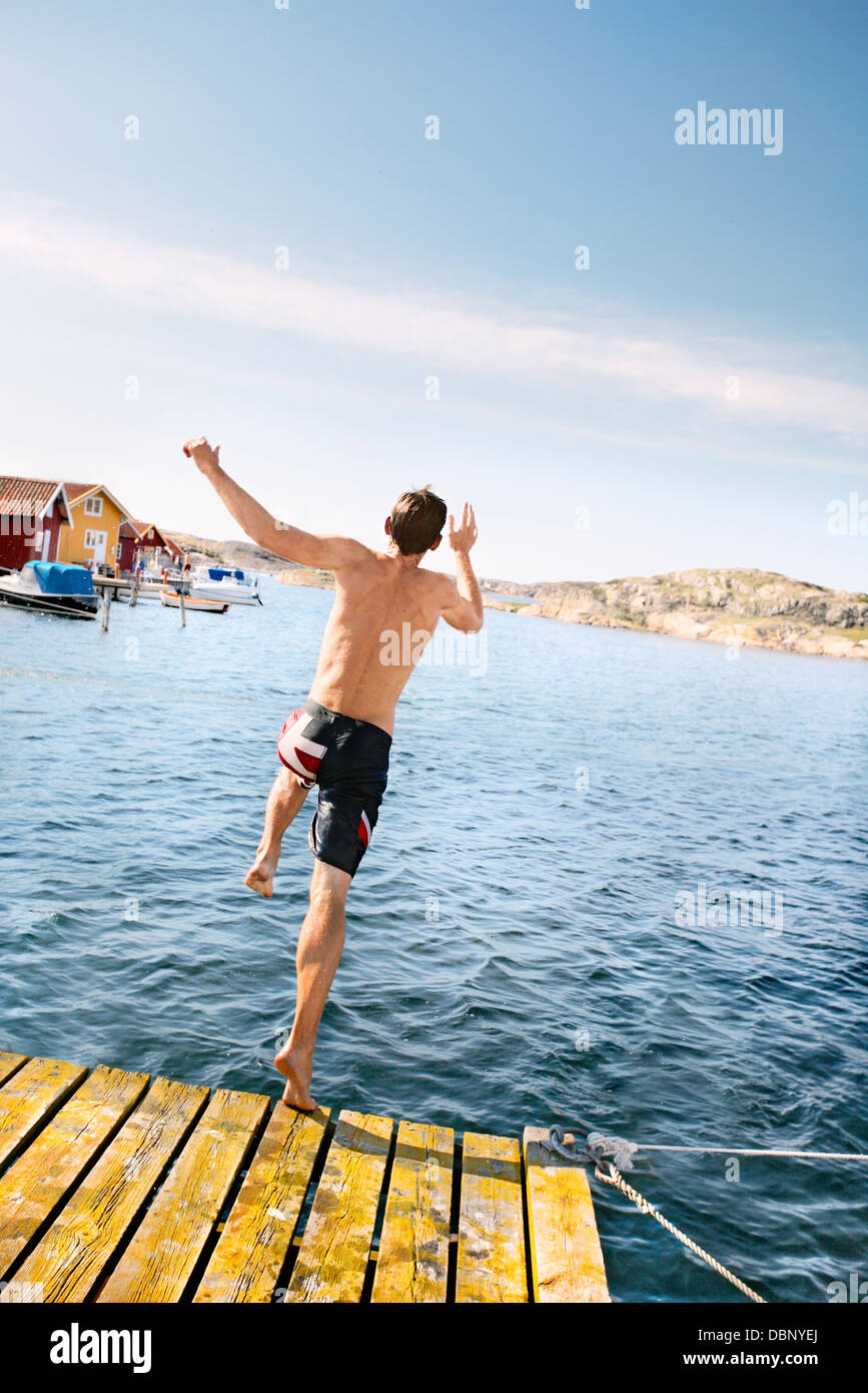 rear view of man jumping into water Stock Photo - Alamy
