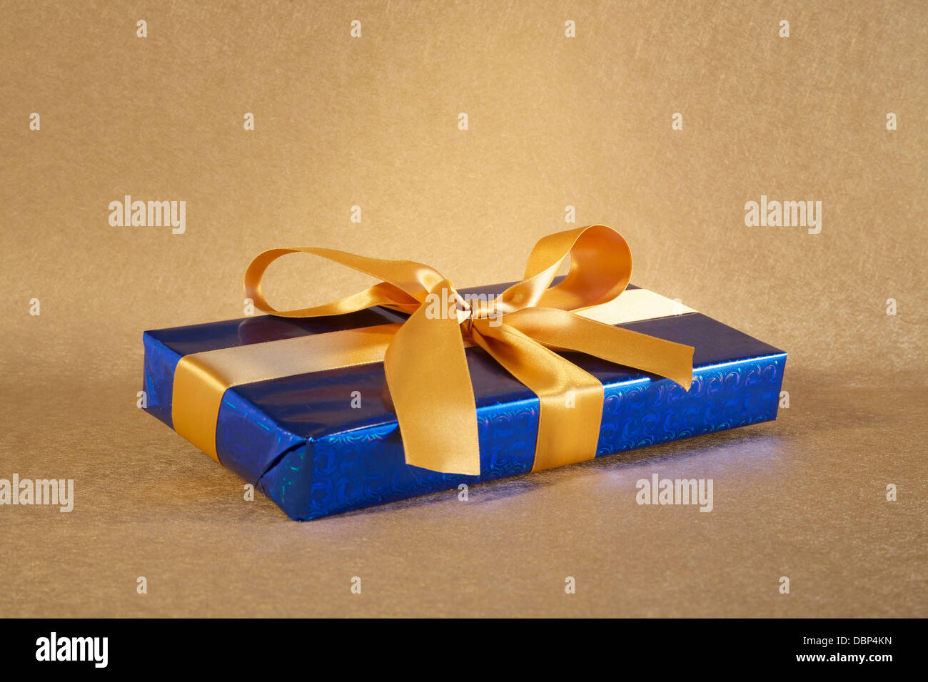 brilliant blue gift box with golden bow Stock Photo - Alamy
