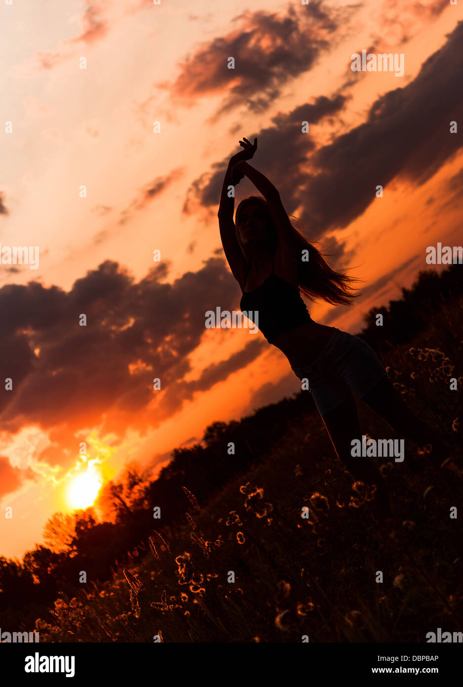Silhouette of a dancing young girl against the sunset sky Stock Photo ...