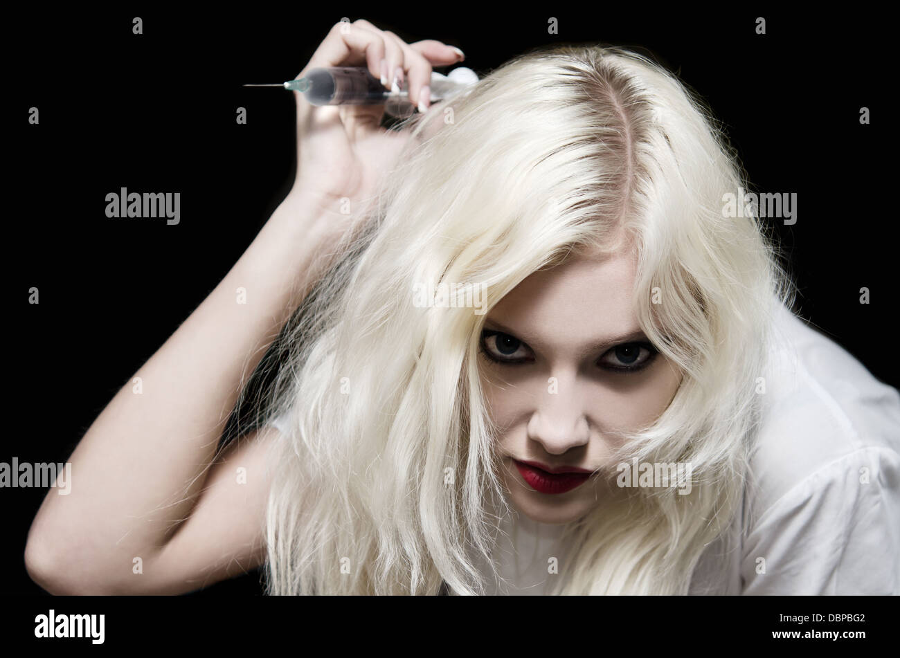 Beautiful young girl in the image of evil nurse with syringe in hand ...