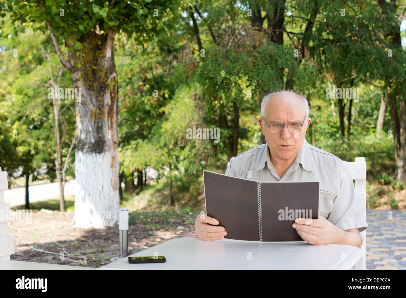 Mature Caucasian man reading the menu at a restaurant, keeping his ...