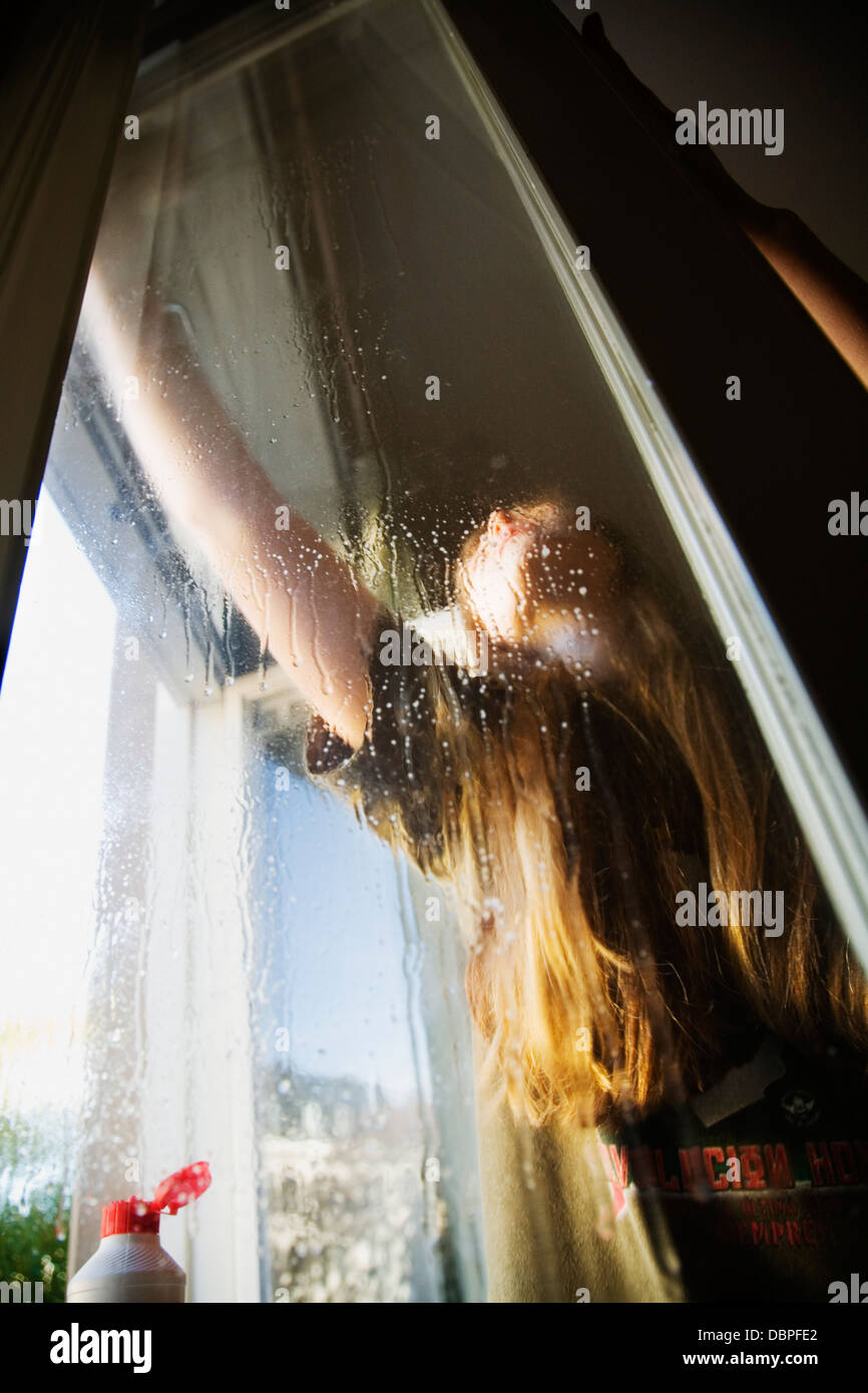 Girl (16-17) cleaning window at home Stock Photo - Alamy