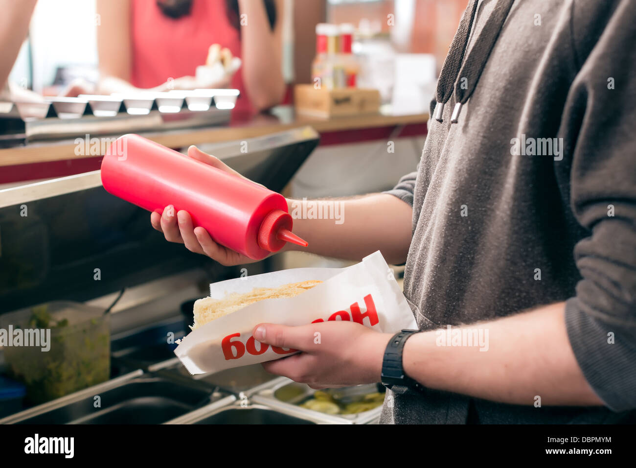 Hotdog - friendly salesman and fresh ingredients in a fast food snack ...