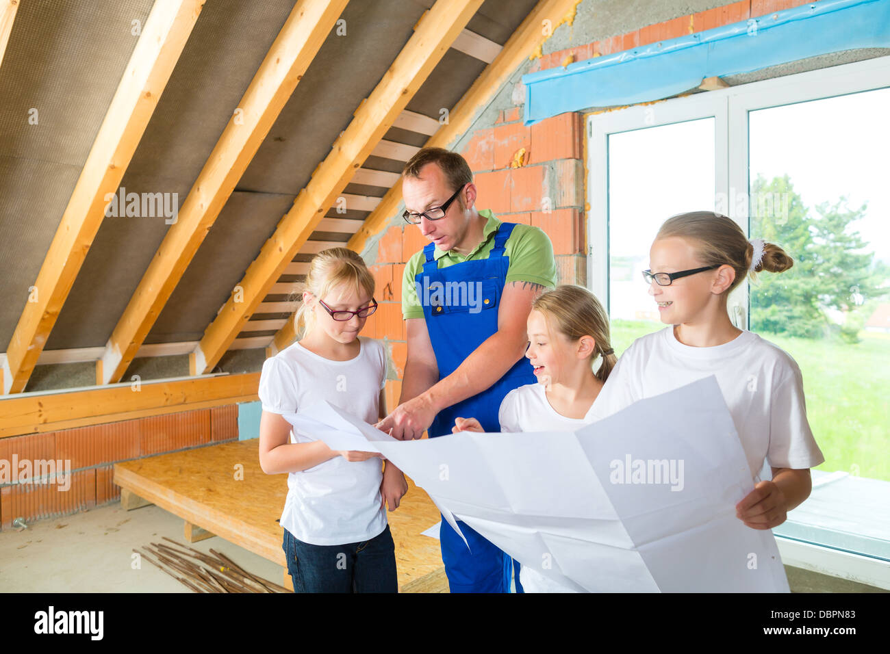 Father and kids or daughters and friends looking at a construction plan ...