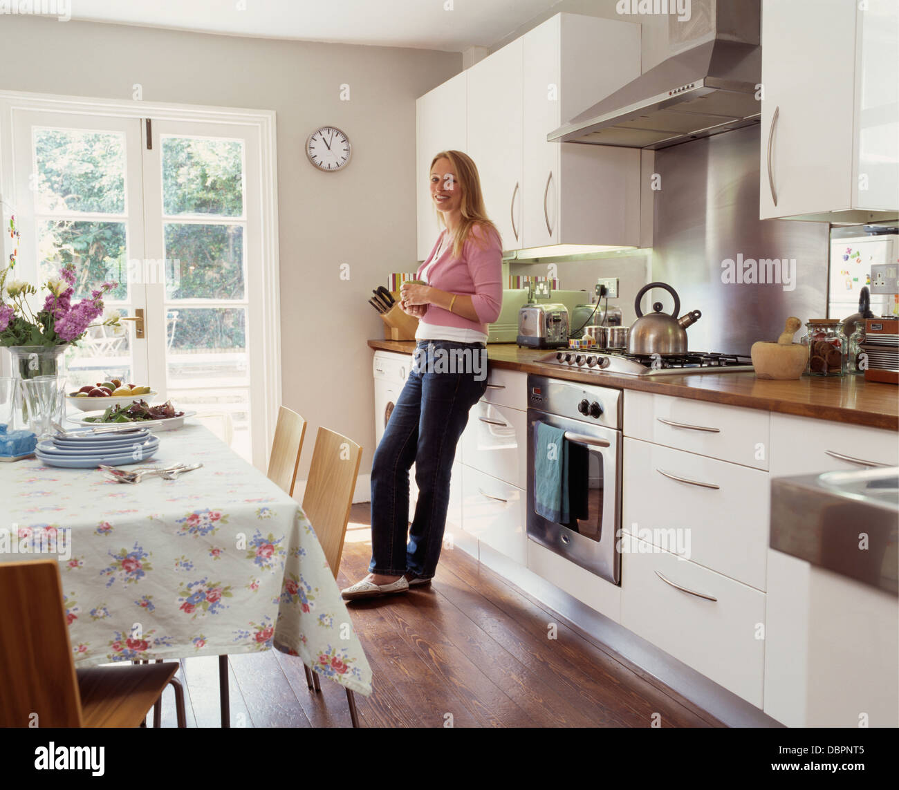Portrait of smiling woman in modern kitchen Stock Photo - Alamy