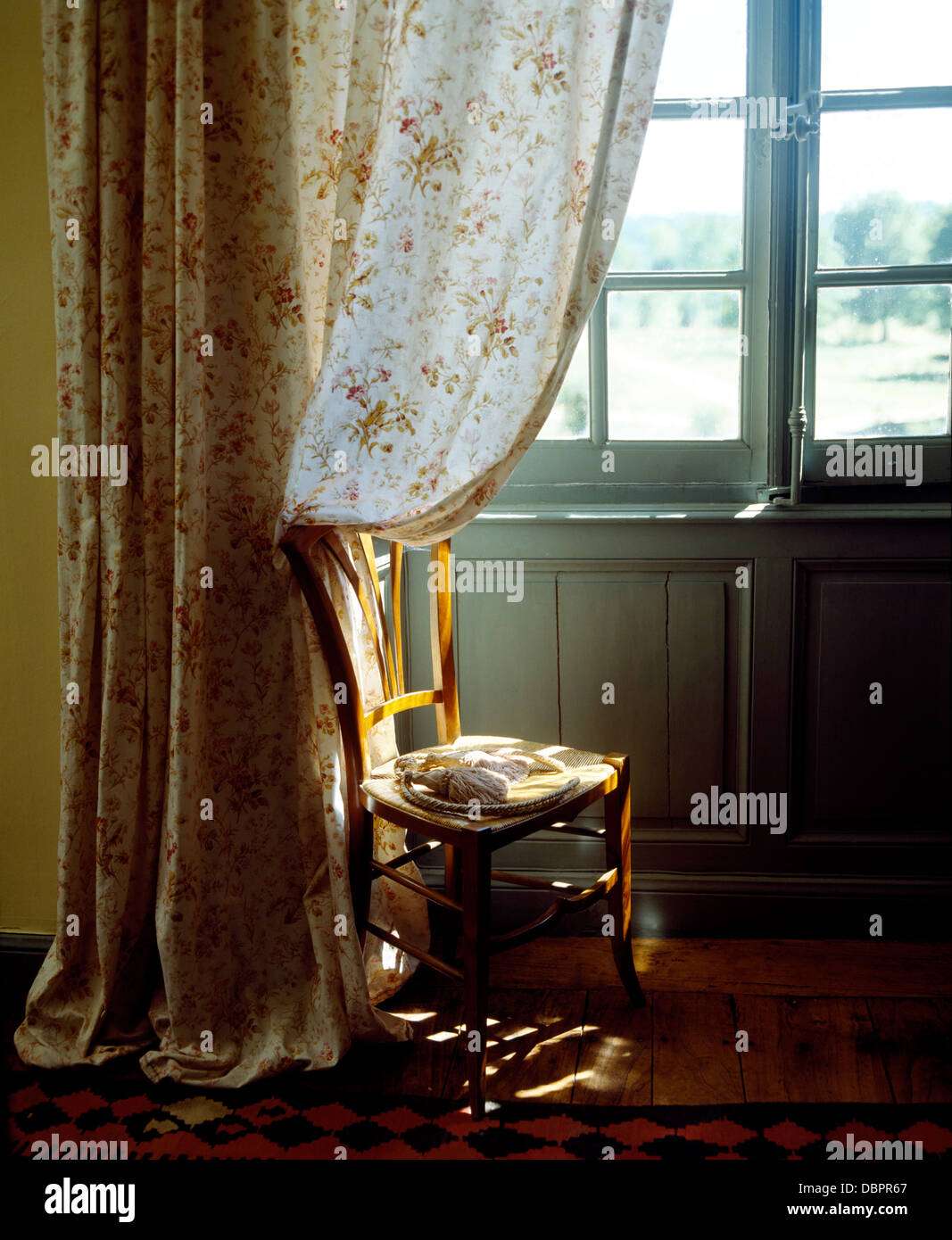 Antique chair beside window with neutral floral patterned curtain Stock ...