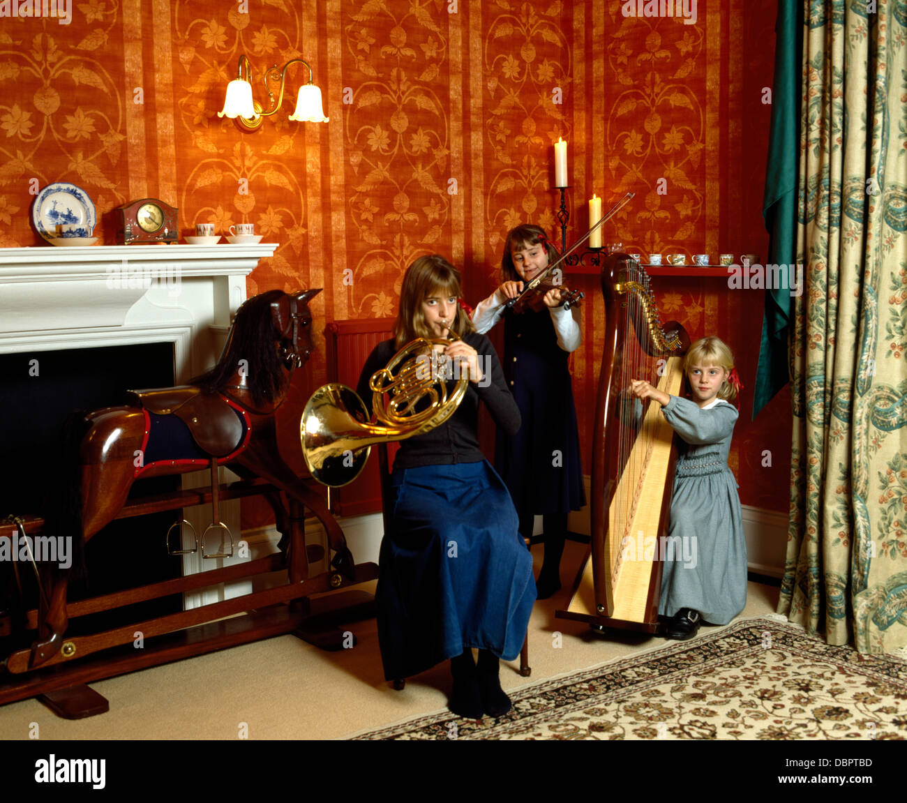 Three girls playing musical instruments in country drawing room Stock ...