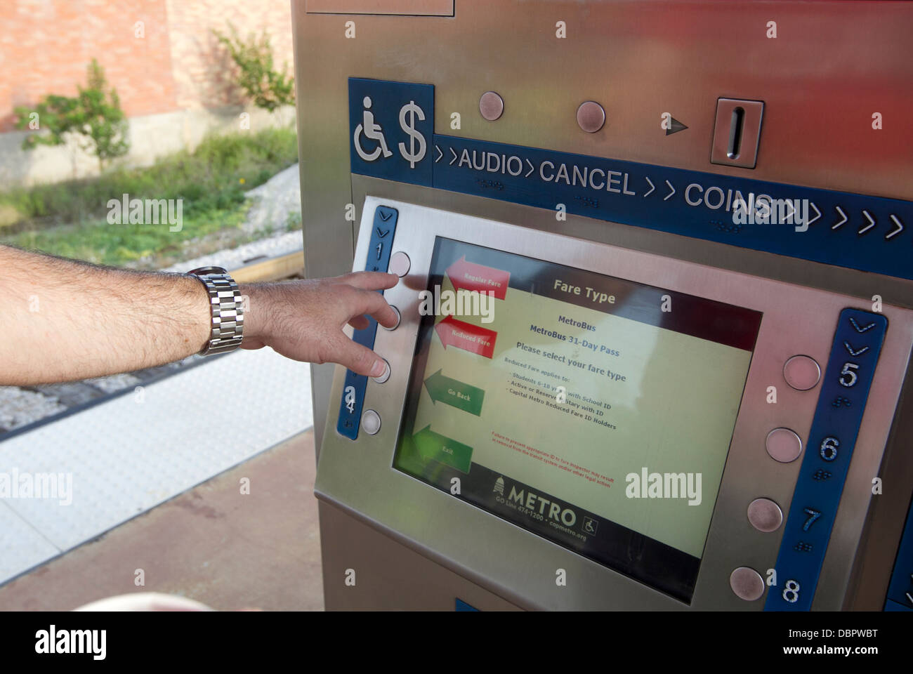 Morning commuter uses the Metro-Rail ticket payment kiosk at public ...
