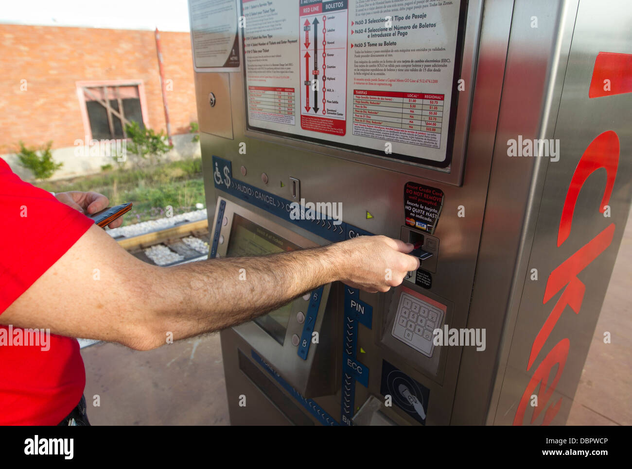 Morning commuter uses the Metro-Rail ticket payment kiosk at public ...