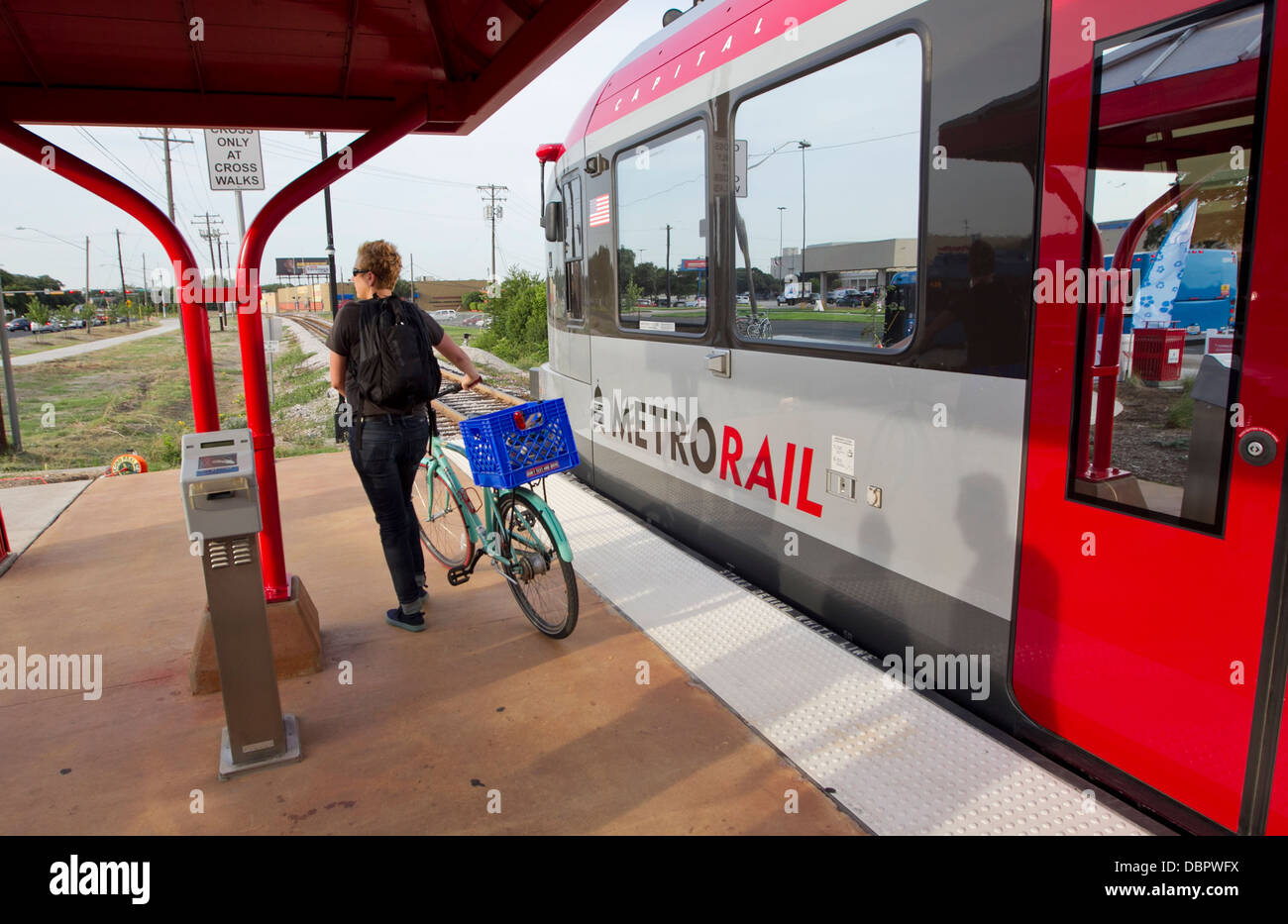 Female commuter exits a metro-rail train with her bicycle at a public ...