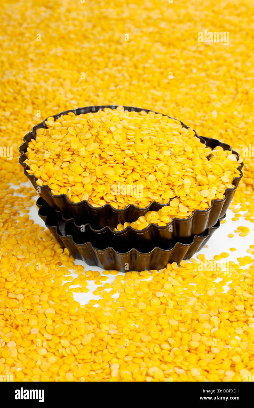 Yellow lentil in form with lentil background Stock Photo - Alamy