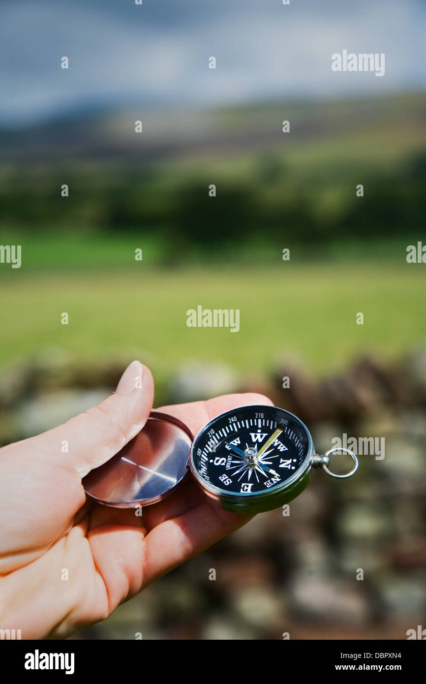 Female hand holds compass up to establish direction Stock Photo - Alamy