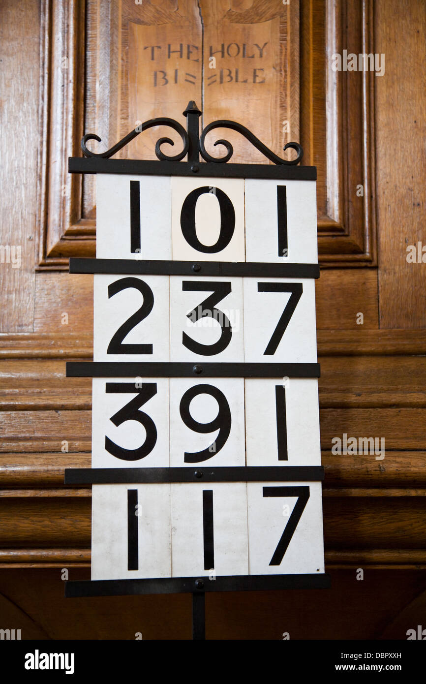 Hymn board with four Hymn numbers set against a traditional wooden ...
