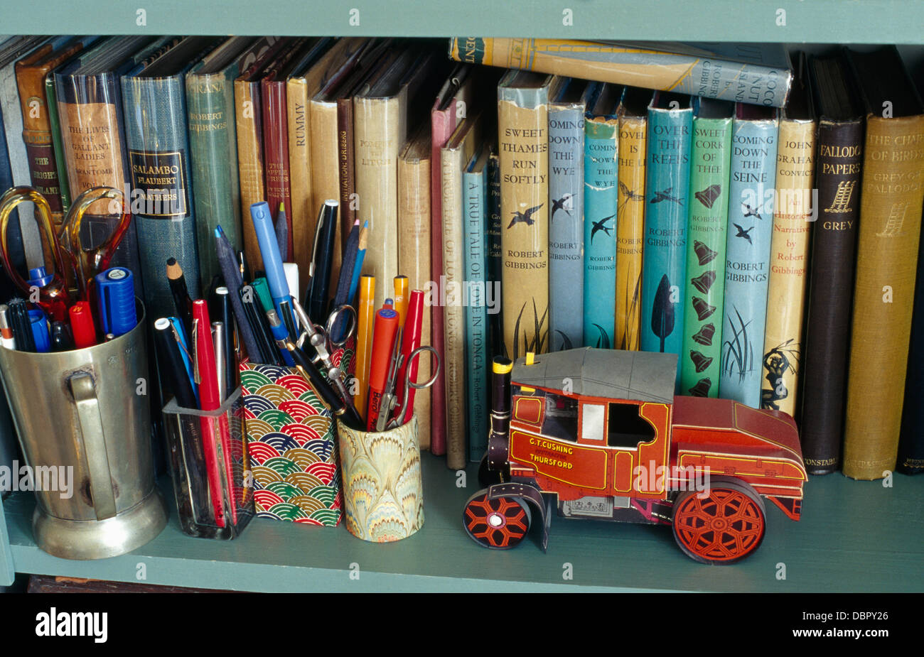 Close-up of pots of pens and pencils on shelves with collection of ...