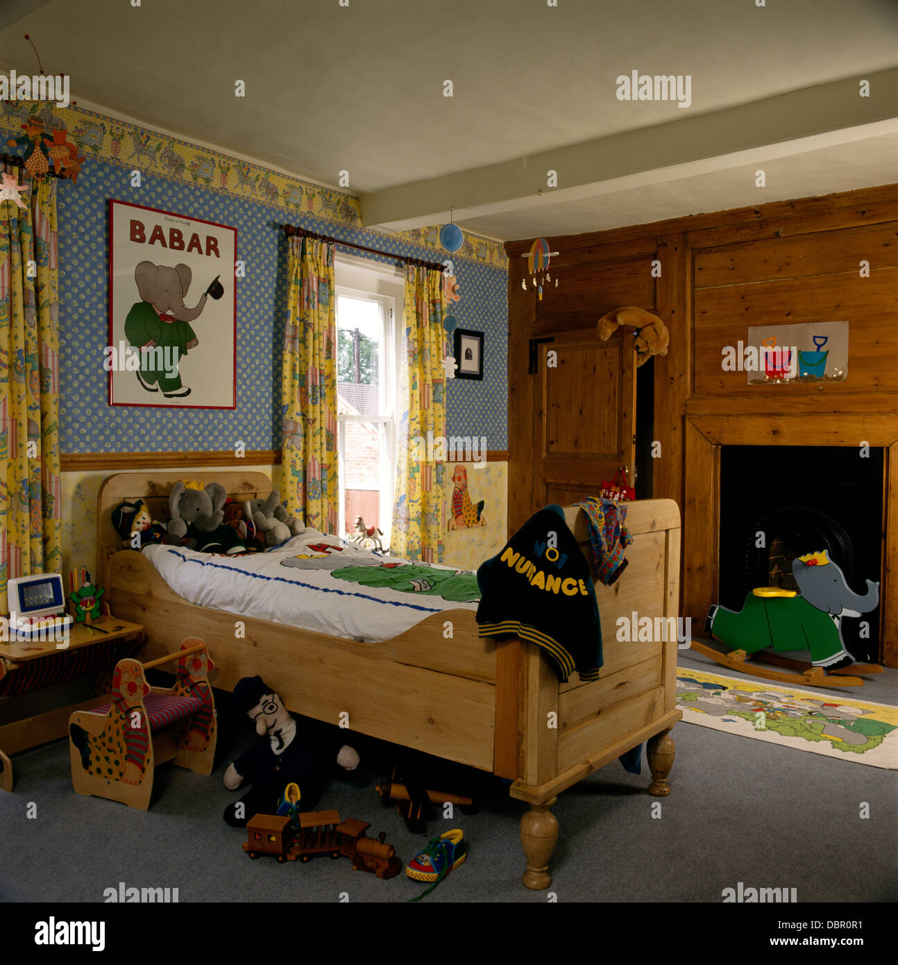 Babar poster on wall above vintage pine bed in child's bedroom with ...