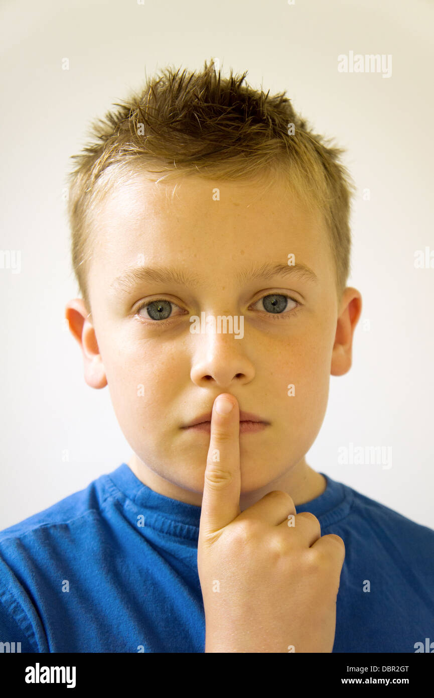 Boy holding his finger to his lips Stock Photo - Alamy