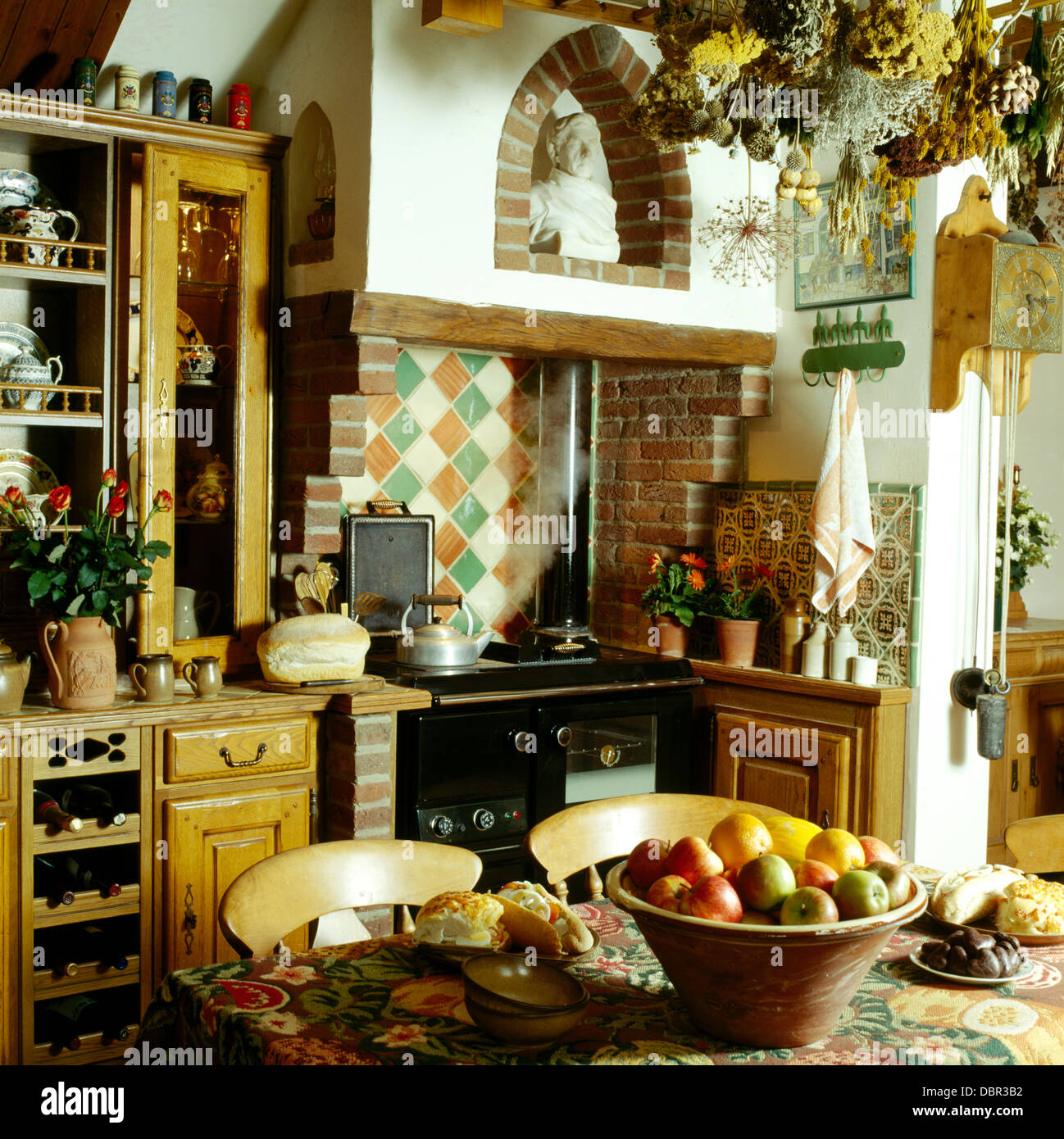 Large earthenware bowl of apples on table in country kitchen with ...