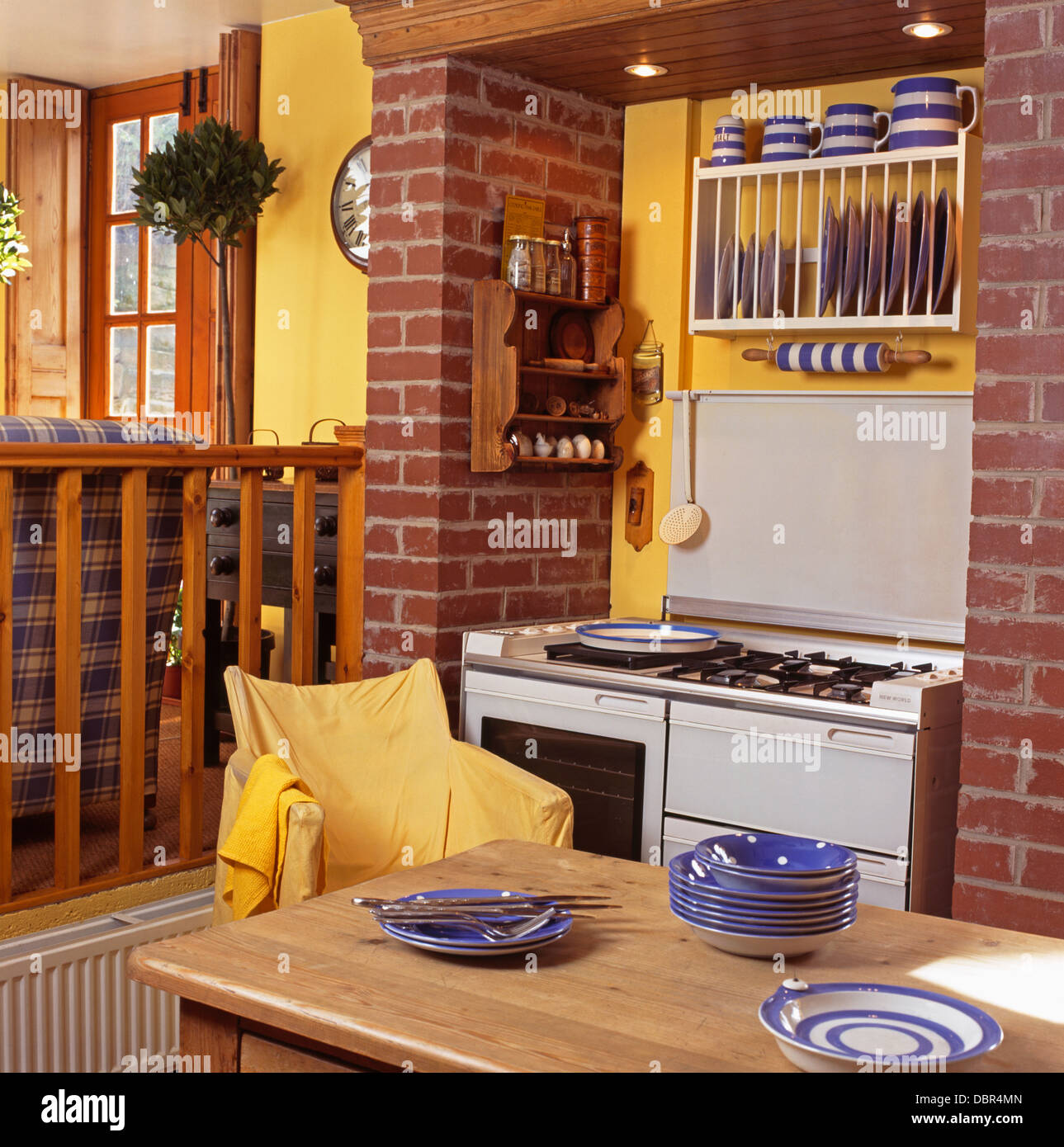 Yellow director's chair at table with blue dishes in yellow kitchen ...