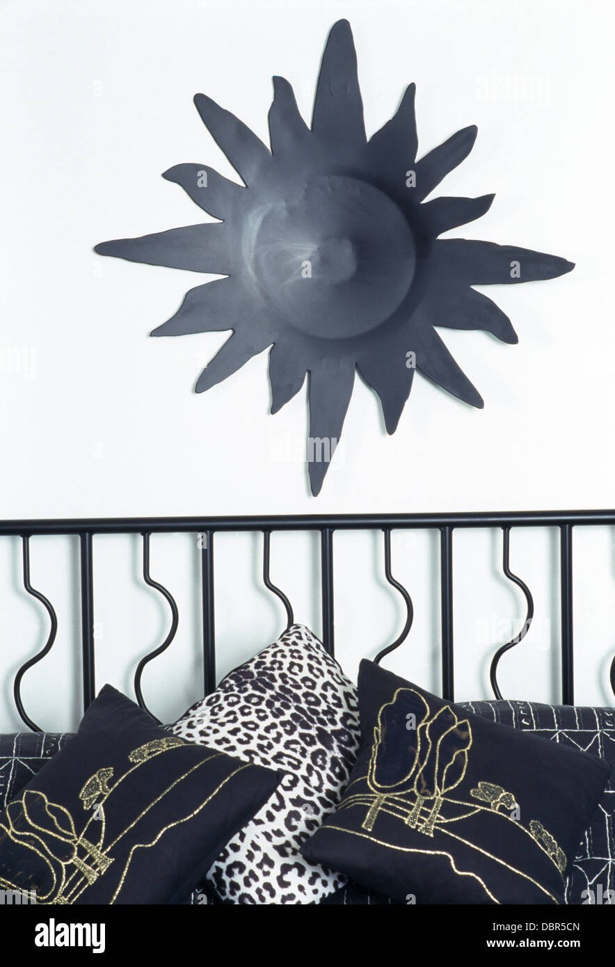 Black 3D star burst above metal bed with black cushions in white ...