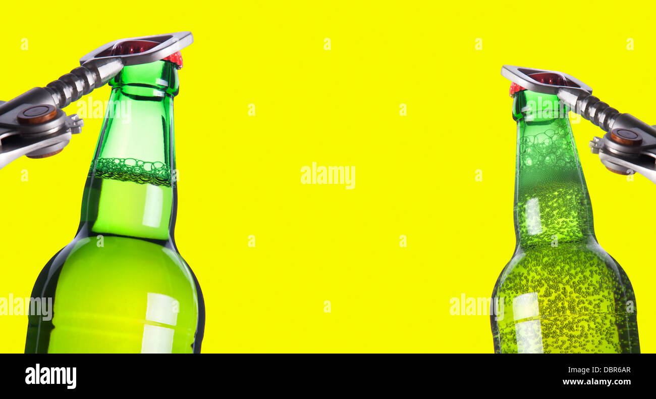 Opening beer bottle with metal opener on a yellow Stock Photo - Alamy