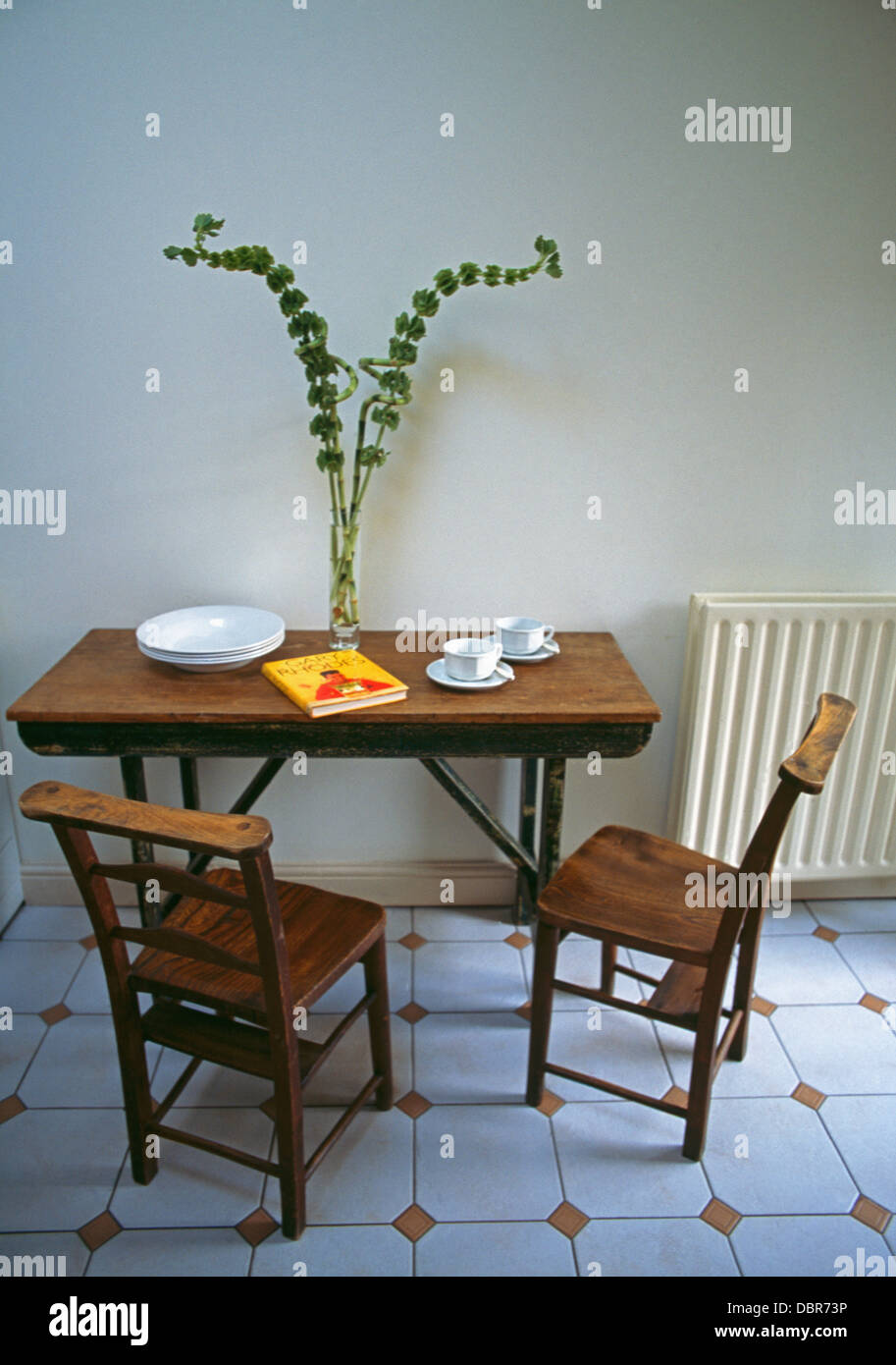Old chapel chairs at simple wood table in economy-style dining room ...