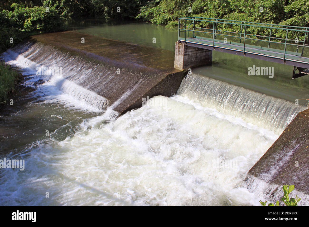 a dam retaining water from a swollen river with its bridge and ...