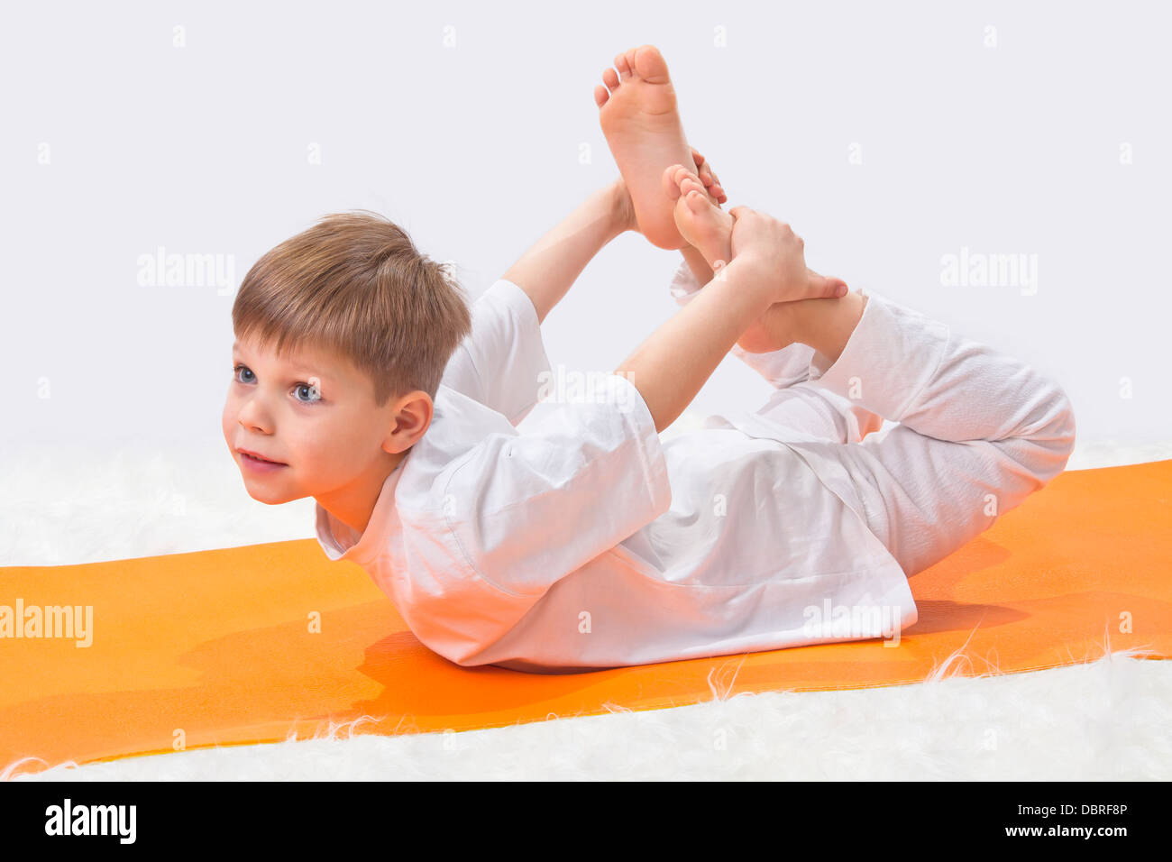 Children's yoga. The little boy does exercise Stock Photo - Alamy