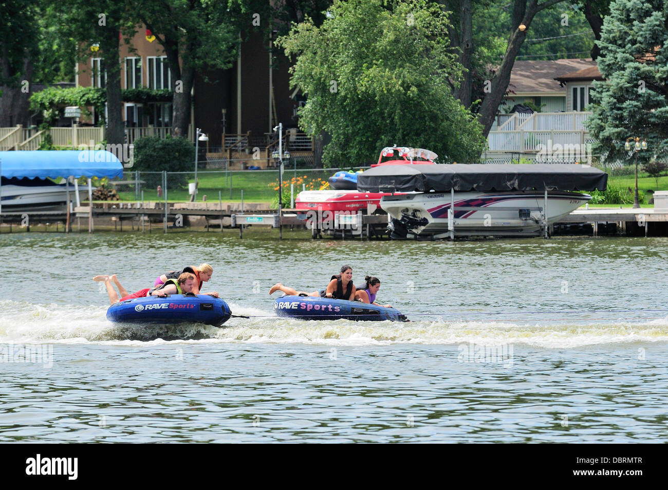 Teenagers tubbing on a river Stock Photo - Alamy